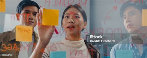 아시아 기업인들은 투명한 유리 벽 뒤에 서서 진행 작업을 가리키는 관리자를 듣고 사무실에서 회의와 노동자 포스트 스티커 메모를 브레인 스토밍합니다 교습에 대한 스톡 사진 및