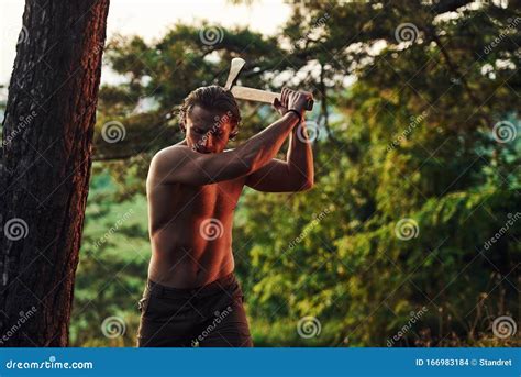 Process Of Cutting The Tree By Using The Axe Handsome Shirtless Man With Muscular Body Type Is