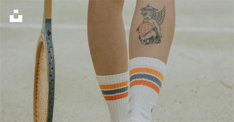 오른쪽 다리에 검은색과 빨간색 별 문신이 있는 흰색 양말과 흰색 양말을 신은 사람 사진 Unsplash의 무료 회색 이미지