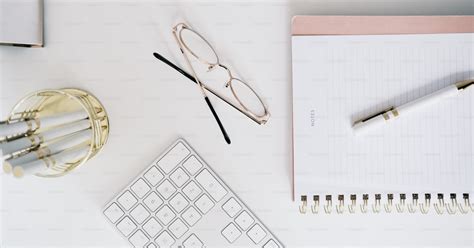 A Desk With A Keyboard Pen Glasses And A Notebook Photo Desktop Image On Unsplash