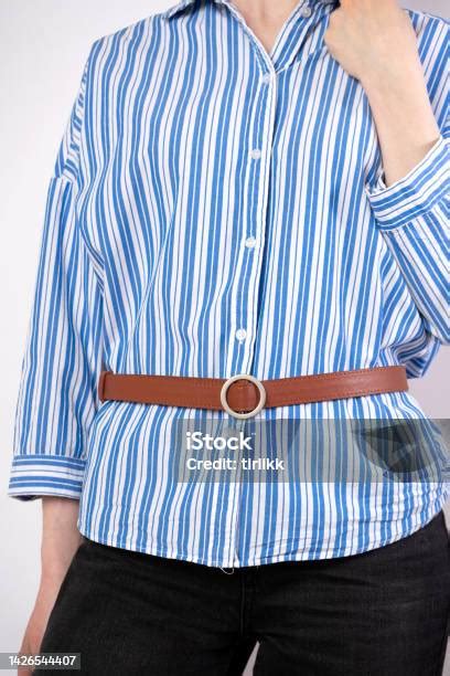 청바지 위에 넓은 긴 줄무늬 블라우스에 얼굴이없는 여성의 초상화 허리에 얇은 벨트 클로즈업 얼굴이없는 주머니에 손 비즈니스