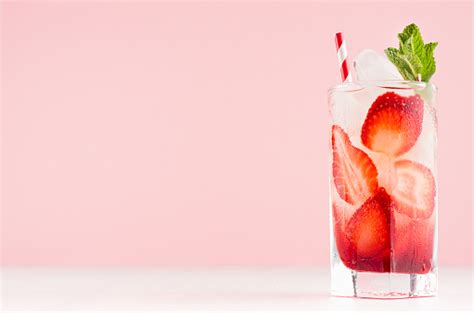 부드러운 현대 분홍색 배경에 향신료 열매 얼음 조각 민트와 줄무늬 밀 짚과 신선한 딸기 칵테일 복사 공간 0명에 대한 스톡 사진