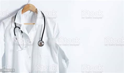 복사 공간이있는 흰색 배경 위에 옷걸이에 청진기와 의사의 흰색 코트 연구실 가운에 대한 스톡 사진 및 기타 이미지 연구실 가운 코트 의복 매달기 Istock