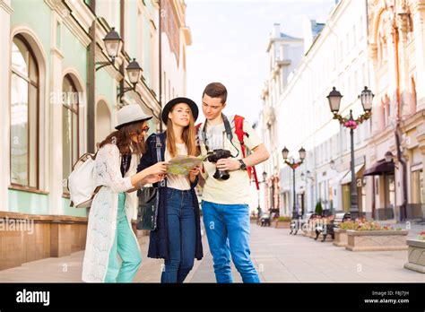 Girls And Guy Holding Camera Look At City Map Stock Photo Alamy