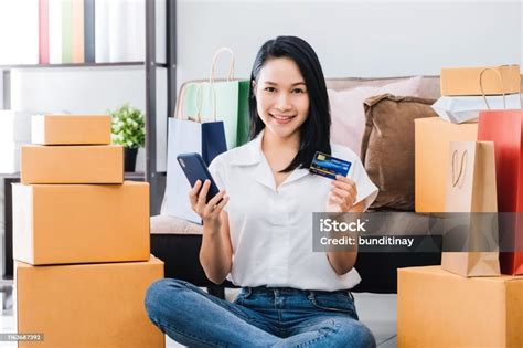 쇼핑 백및 상품 상자와 함께 가정에서 온라인 신용 카드 쇼핑과 스마트 폰을 사용하는 아시아 아름다운 여성 현대적인 비즈니스 기술 개념으로 온라인 제품을 구매하는 편리함