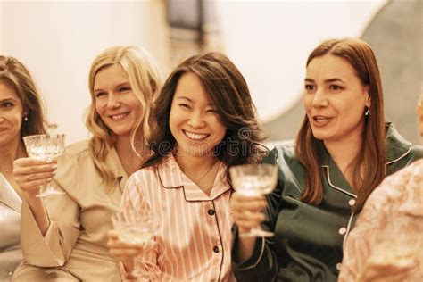 Happy Girls With Glasses Of Champagne Laugh And Raise A Festive Toast