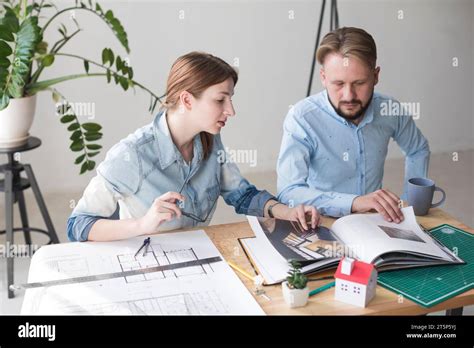 Professional Male Female Architect Looking Catalog While Working Office Stock Photo Alamy
