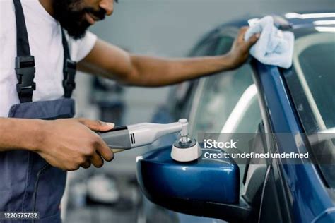 자동차 세부 사항 및 연마 과정 손에 광택기를 들고 자동차 거울을 연마하는 젊은 아프리카 계 미국인 남자의 이미지를 클로즈업 폴란드어 기계로 손에 초점 직업에 대한 스톡