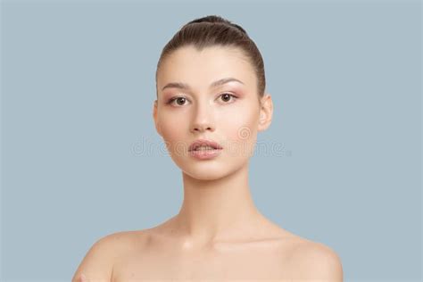 Woman With Clean Skin Touches Her Cheeks With Her Hand Face Skin Concept On A Blue Background