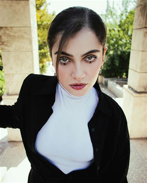 검은색 스웨터 긴 머리 다채로운 초상화 대조 대중 문화 도시 스타일 도시의 따뜻한 음색 라이프스타일 부드러운 조명 분홍색 배경 비니 비니 모자 빨간