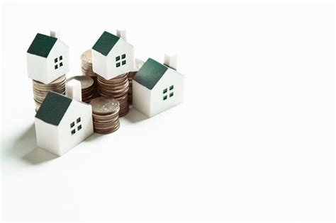 집 마을 모형은 동전 흰색 배경으로 쌓여 있다 주택 담보 대출 금리 대출 개념 금융 주택 소유 투자 금융 성장 시장 기회 부동산 부동산 자산 관리 개념에 대한 스톡 사진 및