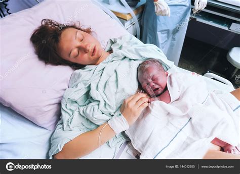 Mother Holding Her Newborn Baby After Labor In A Hospital Stock Photo