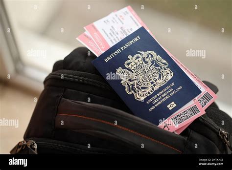 Blue British Passport With Airline Tickets On Touristic Backpack Close