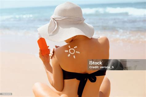 선크림 선탠 로션 아름다운 여성 태양의 형태로 어깨에 아름다운 에 적용 스킨 케어 자외선 차단 소녀는 모이스처라이저 선블록을 사용합니다 긍정적인 감정 표현에 대한 스톡 사진