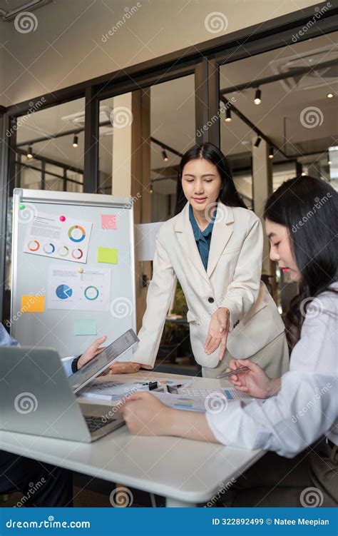 Business Team Collaboration On Data Analysis In Modern Office Setting With Charts And Laptops