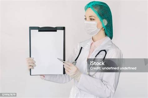 빈 빈 펜과 펜을 손에 들고 있는 청녀 의사 흰색 코트 청진기 의료 얼굴 마스크와 모자를 입고 여성 의사는 빈 종이와 클립 보드를 보여주는 흰색 배경에 격리 Stem 주제에