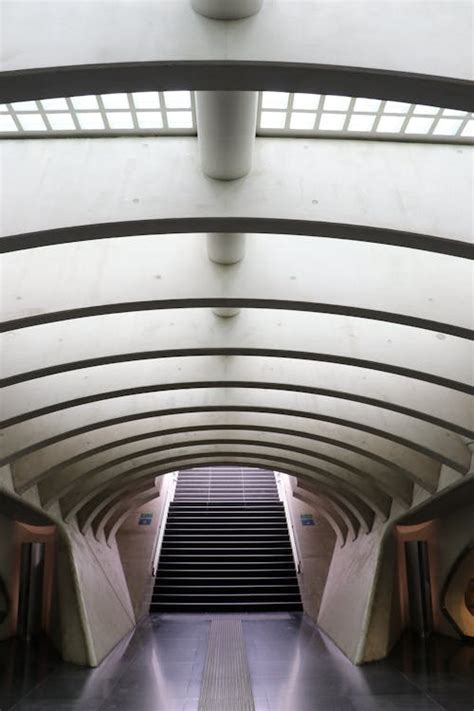 콘크리트 건물의 복도를 따라 사람들 · 무료 스톡 사진