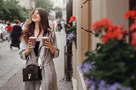 아름 다운 머리카락과 미소 두 커피 컵을 들고와 도시의 거리에서 걷고 Hipster 세련 된 소녀 종이 컵 커피를 즐기는 시간을