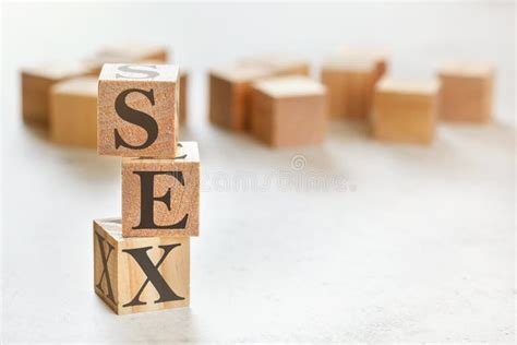 Three Wooden Cubes With Word Sex On White Table More In Background