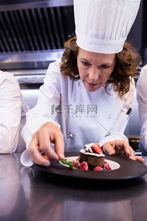 女厨师用薄荷叶装饰甜点高清摄影大图 千库网