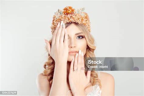 아름다움 왕관 여왕 여자 여자 미스 신부 손 주위에 매니큐어 젤 아트 손톱을 보여주는 얼굴을 보여주는 흰색에 카메라를 보고 풀