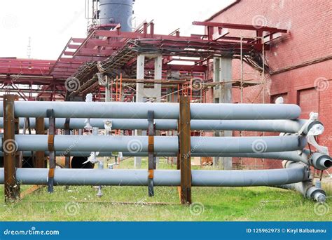 A Large Iron Metal Piping Trestle With Pipes And Electric Wires And