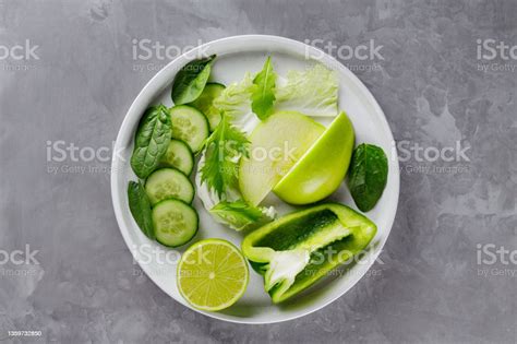회색 배경에 녹색 과일과 야채를 슬라이스 흰색 접시에 신선한 녹색 다이어트 음식 건강한 채식 주의 식품 개념 공간을 복사합니다 위쪽 보기 개념에 대한 스톡 사진 및 기타