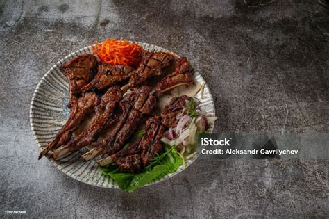 레스토랑 메뉴에서 요리를 제공합니다 회색 돌 탁자 맛있는 케밥에 접시에 강판 당근과 허브를 곁들인 구운 쇠고기와 돼지고기 고기 0명에 대한 스톡 사진 및 기타 이미지
