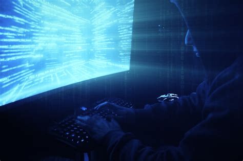 Premium Photo A Man Hacker In A Hood In A Dark Room