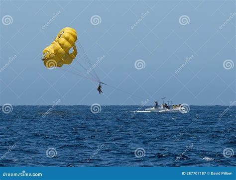 Two People Parasailing Behind A Boat On The Pacific Side Of Cabo San
