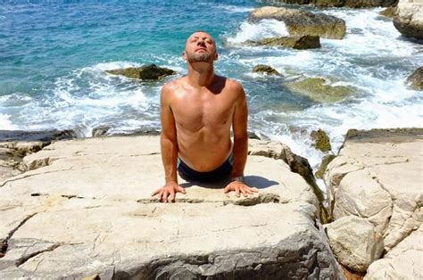 Premium Photo Shirtless Man Doing Yoga On Rock At Beach