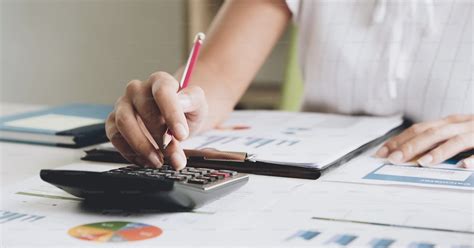 사무실 및 비즈니스 작업 배경 세금 회계 통계 및 분석 연구 개념에서 나무 책상에 수학 금융을 수행하기 위해 계산기와 노트북을 사용하는 비즈니스 여성을 닫습니다 사진