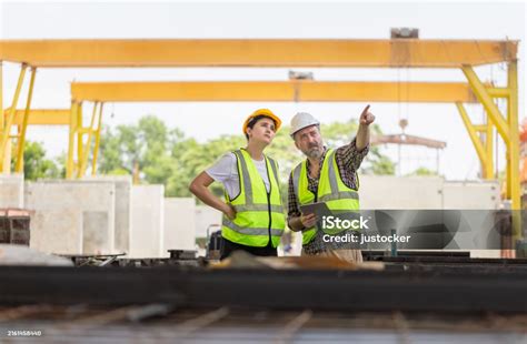 건설 현장에서 논의하는 안전모를 쓴 엔지니어와 감독 프리캐스트 콘크리트 공장 현장에서 태블릿 검사 프로젝트를 진행하는 엔지니어와 작업자 팀 25 29세에 대한 스톡 사진 및