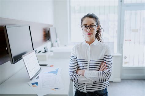 안경 및 포니 테일 옷을 입은 심각한 백인 사업가 팔을 교차 하 고 카메라를 보고 사무실에서 캐주얼 서 갈색 머리에 대한 스톡 사진 및 기타 이미지 Istock