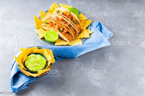 회색 배경에 타코와 토르티야 칩 멕시코 타코 나초 칩 과카몰리 소스가 블루 냅킨을 얹고 있습니다 히스패닉 멕시코 음식 공간을 복사합니다 위쪽 보기 0명에 대한 스톡 사진 및