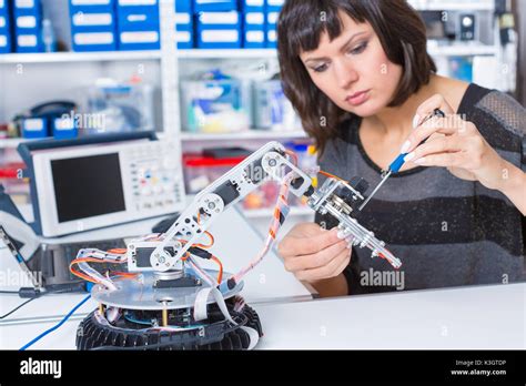 Female In Robotics Laboratory Young Woman Experiment With Robot Stock