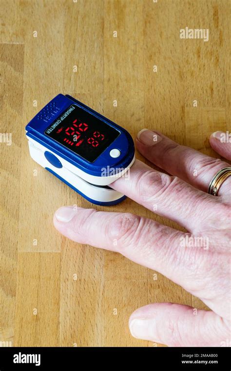 A Woman Using A Pulse Oximeter To Measure The Amount Of Oxygen In Her Blood Stock Photo Alamy