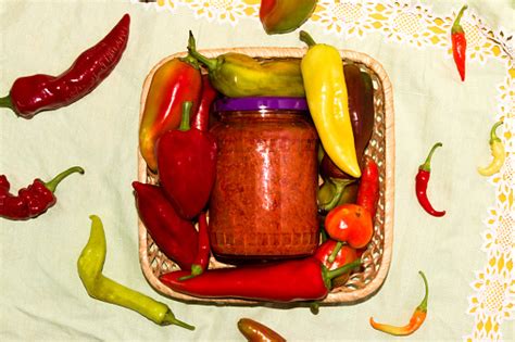 빈티지 고리 버들 나무 바구니 Ajvar와 파프리카 항아리 바구니와 그 옆에있는 고추 빈티지 테이블 장식 전통 발칸 요리 파프리카 및 가지 소스 건강한 생활방식에 대한 스톡