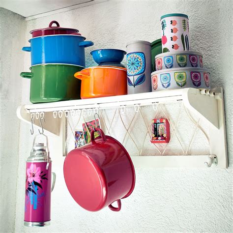 Colorful Pots and Pans Hanging on Wall with Utensil Shelf