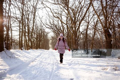 눈 덮인 숲에서 길을 따라 달리는 어린 소녀 어린이를위한 겨울 게임 야외 엔터테인먼트 컨셉 12월에 대한 스톡 사진 및 기타
