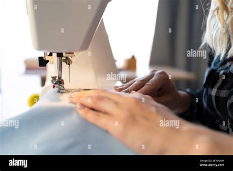 Close Up View Of Sewing Process Female Hands Stitching Blue Fabric On