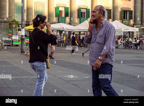 Two People Walking In Opposite Directions At Dantes Square In Naples In The Background There
