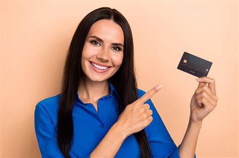 미소를 짓는 멋진 예쁜 소녀의 사진은 베이지색 배경에 격리된 플라스틱 직불 카드를 손가락으로 잡고 있음을 나타냅니다 30 34세에 대한 스톡 사진 및 기타 이미지 Istock