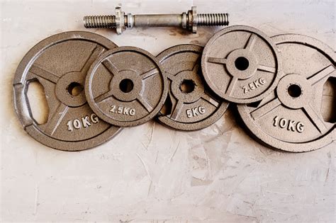 체육관에서 시멘트 바닥에 바벨 또는 아령에 대한 무게 플레이트 웨이트 트레이닝 및 건물 근육을위한 장비 복사 공간이있는 스포츠 또는 운동을위한 개념 배경 주제에 대한 스톡