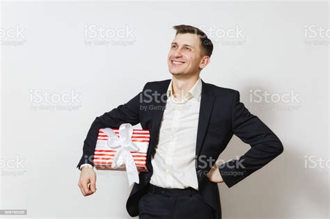 양복 선물 흰색 배경에 고립 된 빨간 선물 상자를 들고 젊은 잘생긴 웃는 남자 광고에 대 한 공간을 복사 합니다 성 발렌타인의 날 국제 여성의 날 생일 휴가 개념 14에