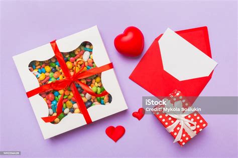 사탕과 선물 상자와 컬러 배경에 발렌타인 하트가 있는 빨간 봉투 플랫 레이 평면도 휴일 개념에 대한 낭만적 인 연애 편지 0명에