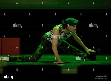 A Young Guy In Military Uniform Is Dancing On Stage In A Stage Light