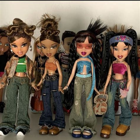 A Group Of Dolls Standing Next To Each Other In Front Of A Wall With