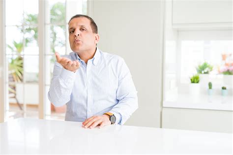 집에 앉아 있는 중 나이 남자는 사랑 스 럽 고 섹시 한 공기에 손으로 키스를 불어 카메라를 보고 사랑 표현 감정에 대한 스톡 사진 및 기타 이미지 Istock