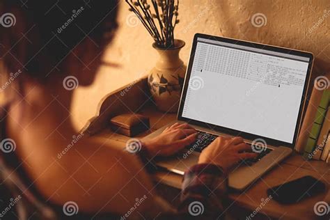 Back View Of Caucasian Female Programmer Siting At Desk Using Laptop
